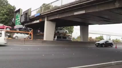 A truck carrying an oversized load hits an overhead bridge on an ...