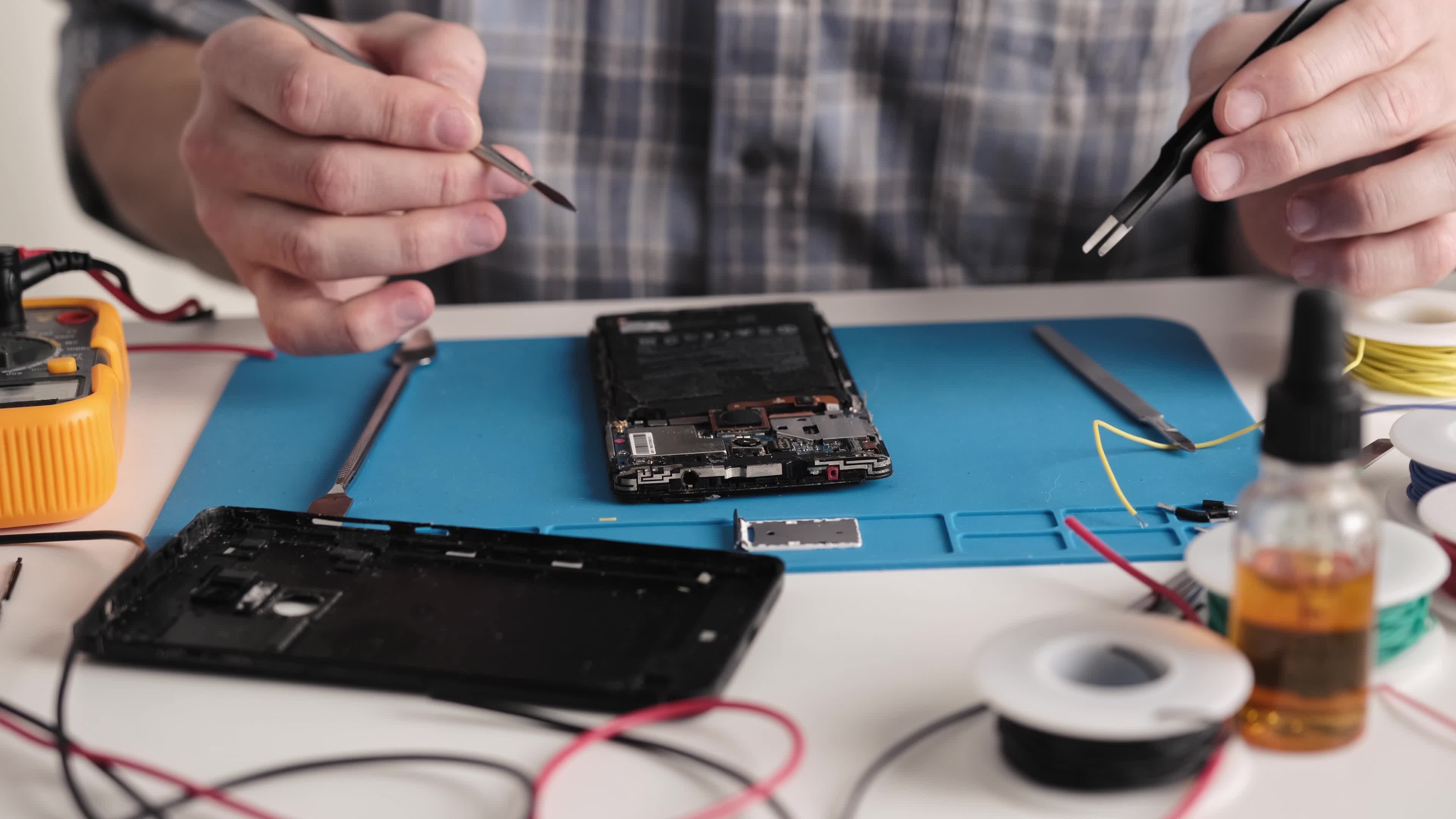 Watch master-in-the-repair-center-fixes-a-broken-smartph-2024-01-12-18 ...