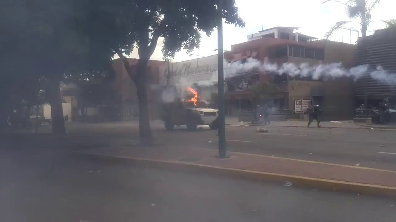 Armoured anti-riot tear-gas grenade launcher vehicle running over ...